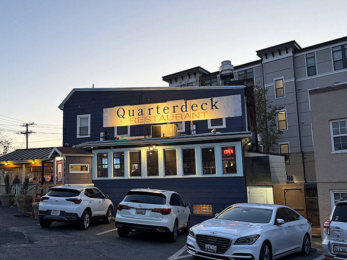 Quarterdeck's illuminated sign glows like a lighthouse beacon, guiding hungry seafood lovers to its doorstep at dusk.