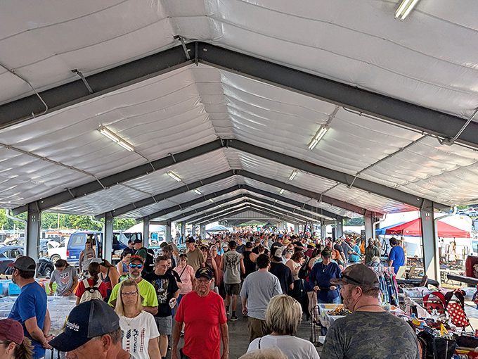 The sheer volume of people and goods beneath this massive white awning generates the low, constant hum of commerce, making the covered area of Rogers Flea Market a dense, exciting labyrinth of bargains.