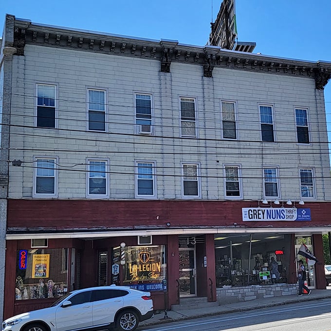 The Grey Nuns Thrift Shop's second location features a classic brick-and-wood storefront. Legion Hall neighbors this community gem where thrifting dreams come true.