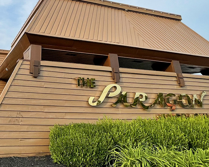 "The Paragon" glows in golden letters against wood paneling. This isn't just a sign&mdash;it's a promise of good times ahead.