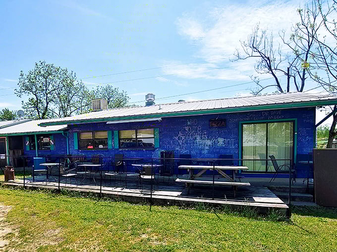 That weathered blue siding holds secrets that would make any pizza lover's heart skip.