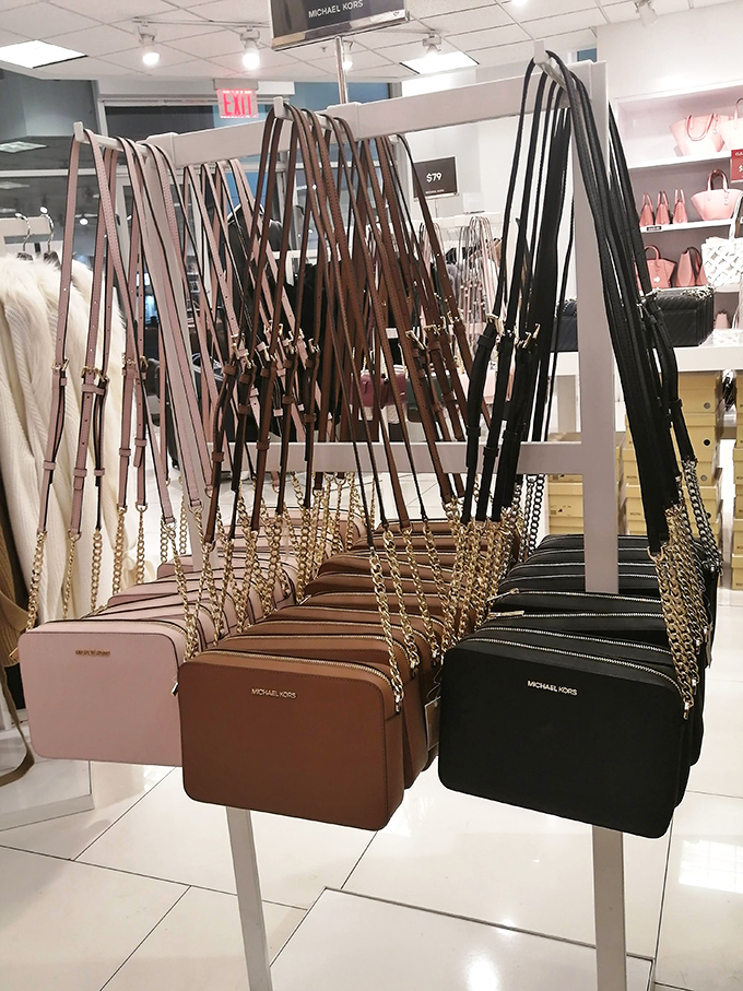 Michael Kors crossbody bags lined up like soldiers ready for deployment &ndash; each one waiting to become someone's prized fashion companion at a fraction of department store prices.