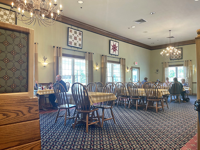 Windsor chairs, quilted wall art, and warm lighting create the dining room equivalent of a grandmother's hug. Comfort begins before the food arrives.