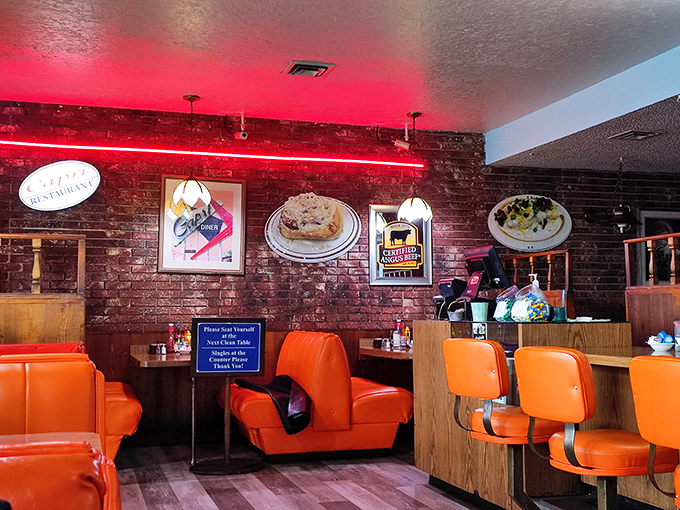 Those orange vinyl booths aren't just seating; they're time machines to when conversations happened face-to-face and ketchup bottles were permanent table residents.