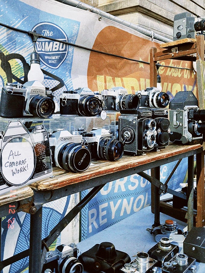 "All cameras work!" promises this vintage photography display. Each Pentax and Canon tells a story waiting to be continued by its next owner.