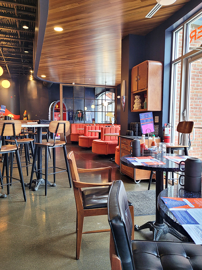 Inside, coral-colored booths and warm wooden ceiling panels create that perfect balance of nostalgic comfort and modern design sensibility.