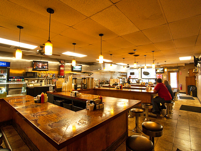 The horseshoe counter isn't just seating—it's a front-row ticket to the breakfast show, where regulars claim their spots like family heirlooms.