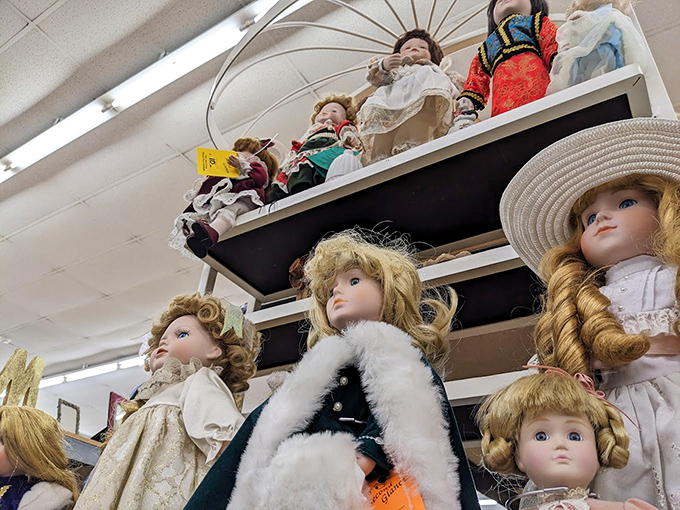The doll collection watches over shoppers with porcelain gazes, silently judging your fashion choices while sporting their own timeless styles.