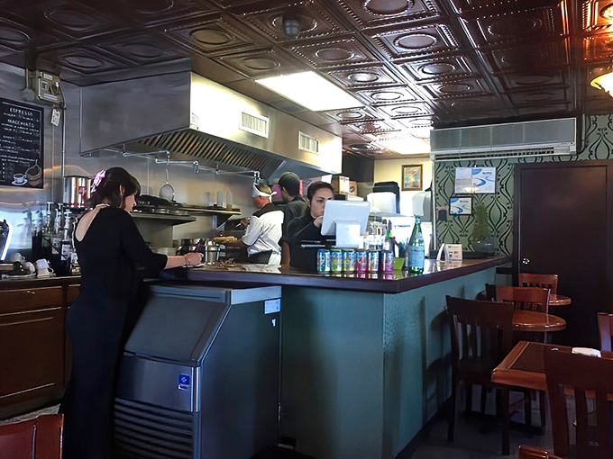 The open kitchen concept lets you witness culinary magic in action—like watching the Food Network, but with the bonus of actually getting to eat the results.