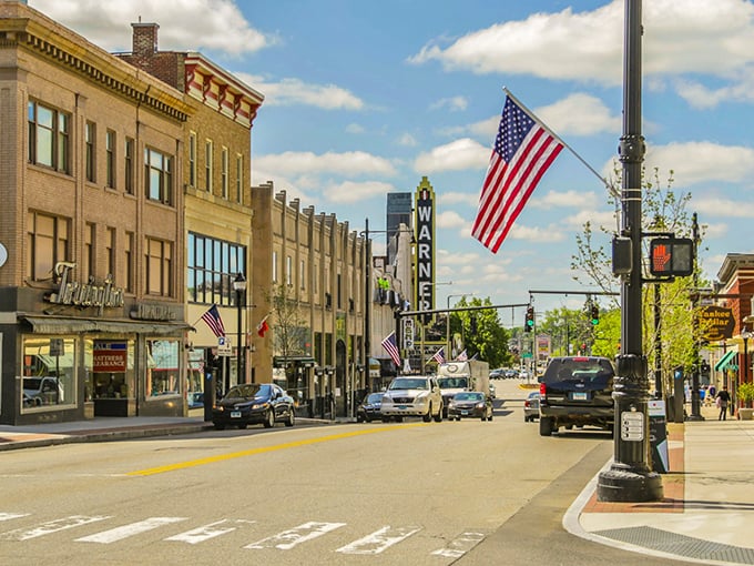 American flags flutter along downtown Torrington, where historic brick buildings house local businesses that survived the retail apocalypse with small-town grit.