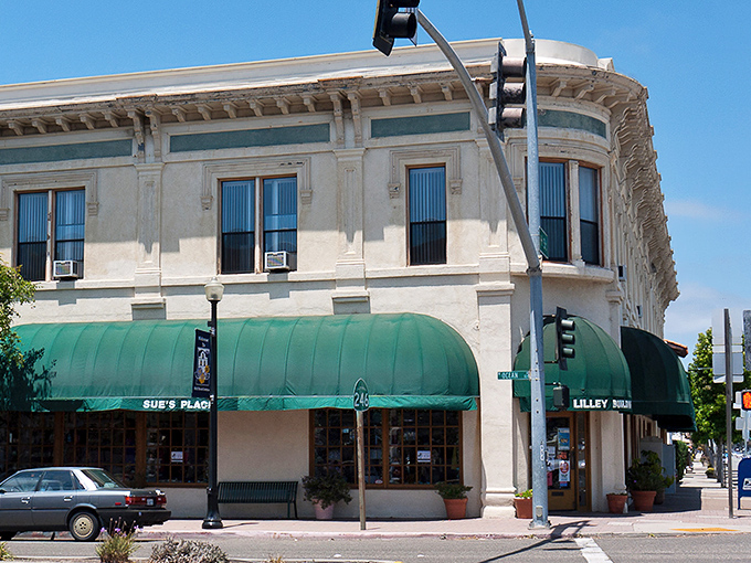 Historic architecture meets modern practicality at this downtown corner. The green awnings provide shade for conversations that often last longer than planned.