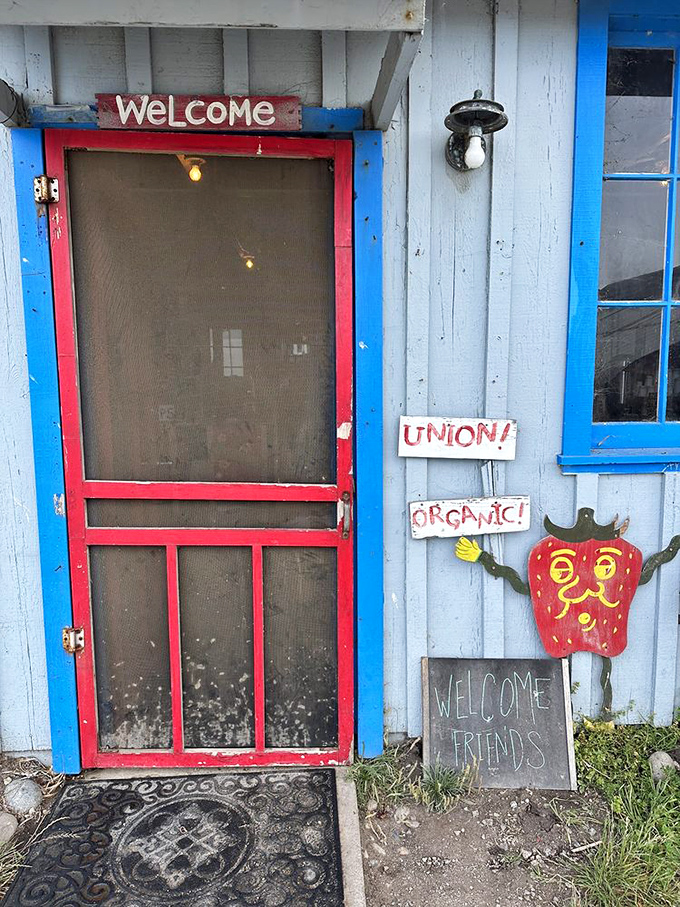The screen door says it all: "WELCOME FRIENDS." This blue farmhouse entrance with its cheerful strawberry mascot is California farm charm personified.