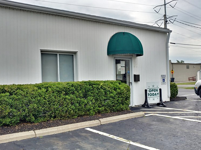The entrance beckons with a simple green awning and an "OPEN TODAY" sign &ndash; your portal to a world where TVs were furniture and remotes didn't exist.