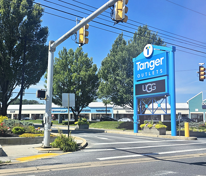 The iconic blue Tanger sign stands sentinel at the entrance, promising brand names without the brand-name prices.