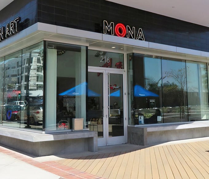 MONA's entrance beckons with a glowing red "O" that seems to wink at passersby, promising a journey through America's electrified commercial history.