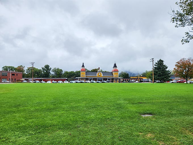 The iconic North Conway station stands proudly against moody skies, its cheerful yellow facade a beacon for adventure-seekers since the Victorian era.