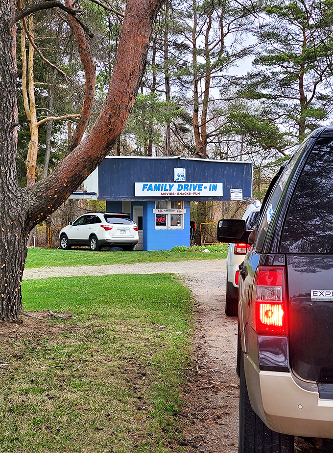 That iconic blue ticket booth welcomes visitors with a promise of "Movies, Snacks, Fun" &ndash; the holy trinity of drive-in perfection.
