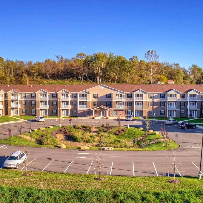 Autumn's golden light bathes the community in warmth, showcasing thoughtful landscaping that proves retirement communities have come a long way since The Shady Pines days.