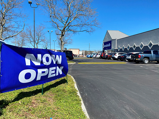 The "NOW OPEN" sign might as well read "ADVENTURE AWAITS"—this parking lot is the launching pad for countless thrifting expeditions.