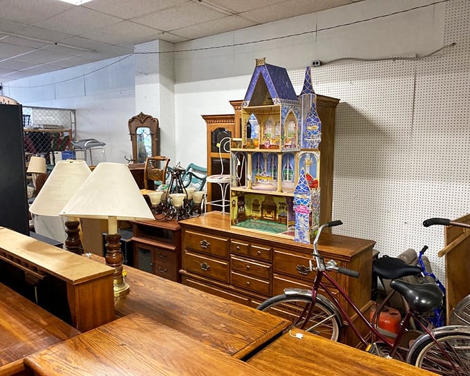 A miniature dollhouse mansion sits regally atop solid wood furniture, proving that at Peter's Park, one person's childhood dream becomes another's conversation piece.