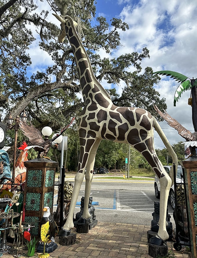 This towering giraffe creates a surreal gateway experience, stretching toward the Florida sky like something from a whimsical safari dream.
