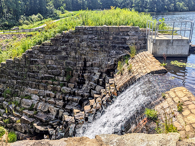 Historic stonework meets rushing water at the dam. Engineering from another era that still manages to hypnotize modern visitors.