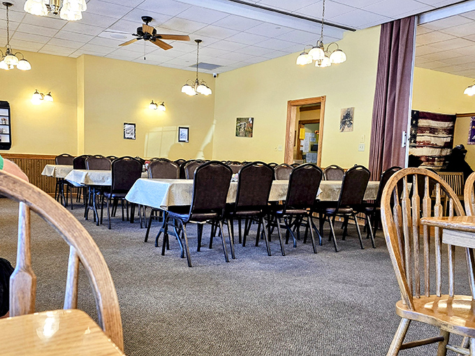 Simple elegance defines the dining room, where ceiling fans lazily spin above tables dressed in crisp white linens, ready for family gatherings.