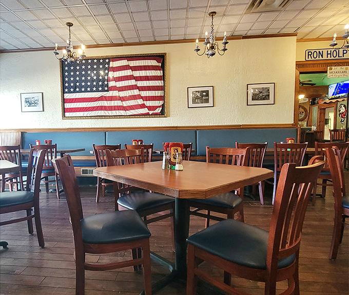 Classic Americana adorns the walls while wooden chairs and tables invite you to settle in. That vintage flag isn't just decoration&mdash;it's a promise of old-school quality.