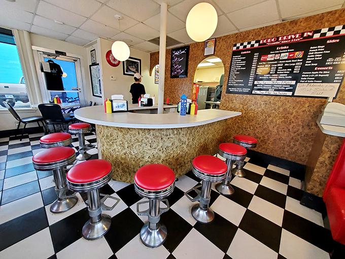 Those cherry-red counter stools aren't just seating—they're front-row tickets to the greatest show in Topeka: the art of the perfect burger.