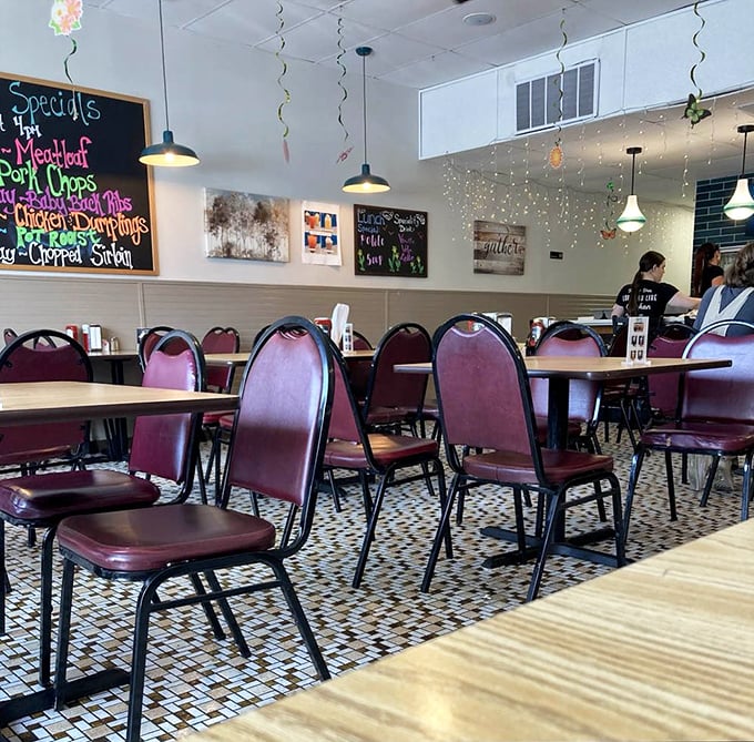 Inside, burgundy chairs and patterned floors create that perfect blend of modern diner comfort with just enough nostalgia to make you feel at home.