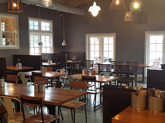 Industrial meets cozy in this thoughtfully designed dining room where wooden tables and eclectic lighting create the perfect pizza-eating sanctuary.