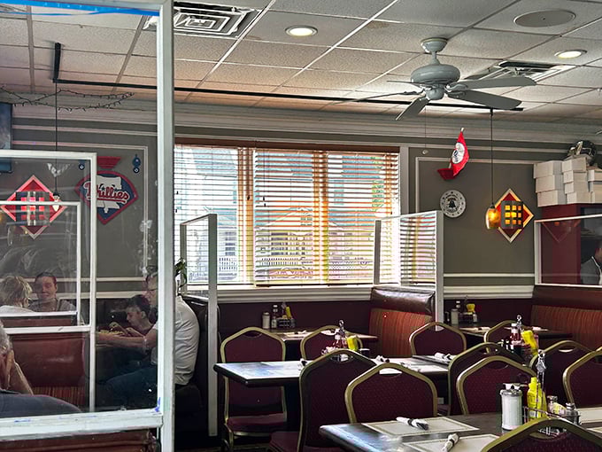 Classic burgundy booths and warm lighting create that perfect diner atmosphere where conversations flow as freely as the coffee.