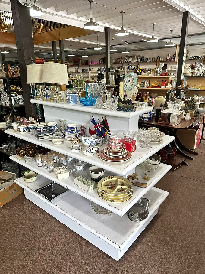 A thrifter's dream display of vintage dishware. Blue and white china mingles with crystal glassware under pendant lights that illuminate decades of dining history.