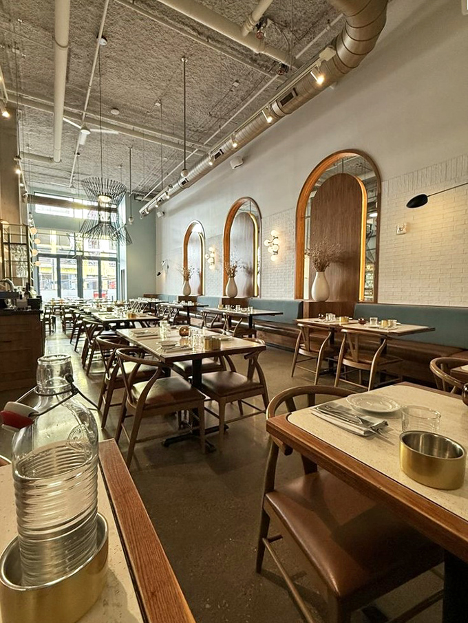 Arched mirrors and warm wood tones create a dining room that feels both modern and timeless. Like a stylish Italian grandmother's living room, if she had impeccable taste.