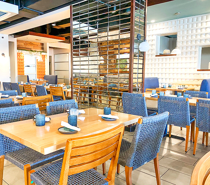 Modern meets traditional in Agave Azul's stylish dining room, where sleek glass dividers and vibrant blue chairs create an atmosphere that's both upscale and welcoming.