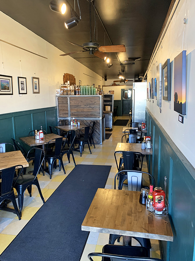 Cozy minimalism at its finest – metal chairs, wooden tables, and local art create the perfect canvas for culinary magic.