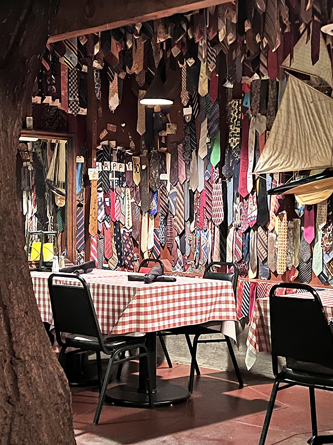 Hundreds of sacrificed neckties hang from the ceiling, each telling the story of a formal dress code left behind for steak nirvana.