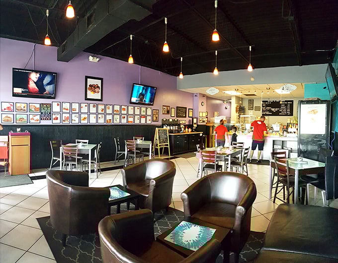 Purple walls and pendant lights create a cozy coffeehouse vibe where donuts are the undisputed stars.
