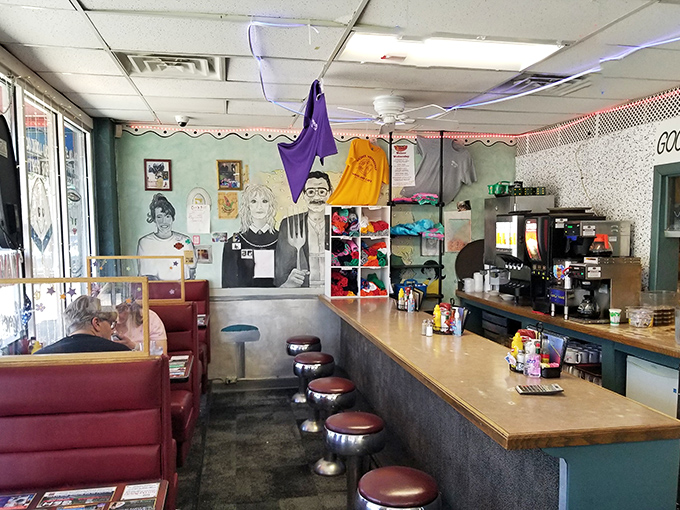 Classic diner counter seating where regulars claim their spots with the dedication of season ticket holders. The mural adds that perfect touch of local character.