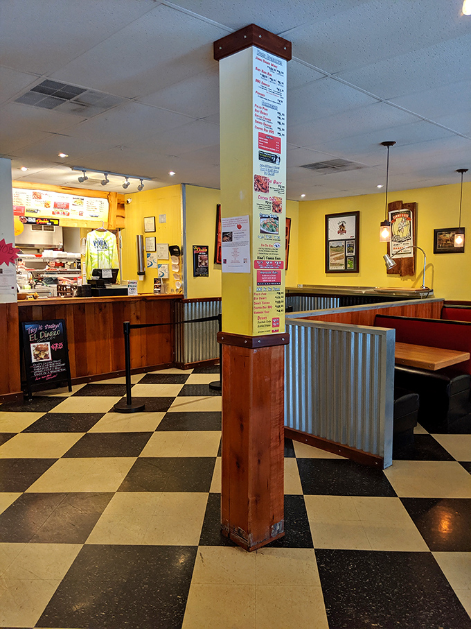 Checkered floors and bright yellow walls create that perfect roadhouse vibe. The corrugated metal accents say "we're serious about our BBQ."