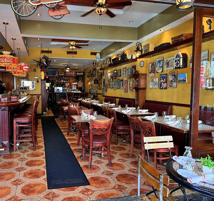 Step inside and the golden walls, vintage posters, and red chairs conspire to transport you to Havana faster than any direct flight ever could.