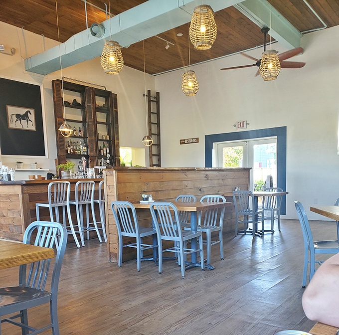 Step inside and discover a rustic-chic interior where wooden beams, wicker pendant lights, and metal chairs create the perfect backdrop for sandwich nirvana.