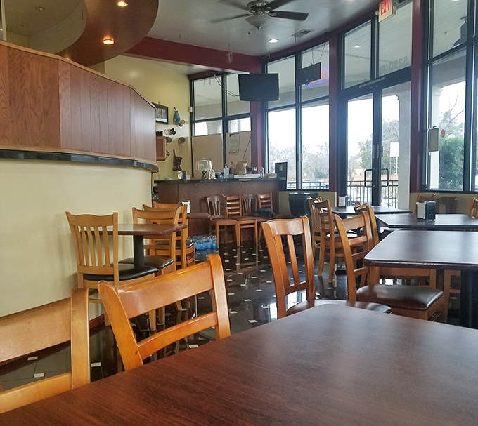 Simple wooden chairs and tables bathed in natural light create the perfect stage for culinary drama. No distractions, just you and extraordinary food.