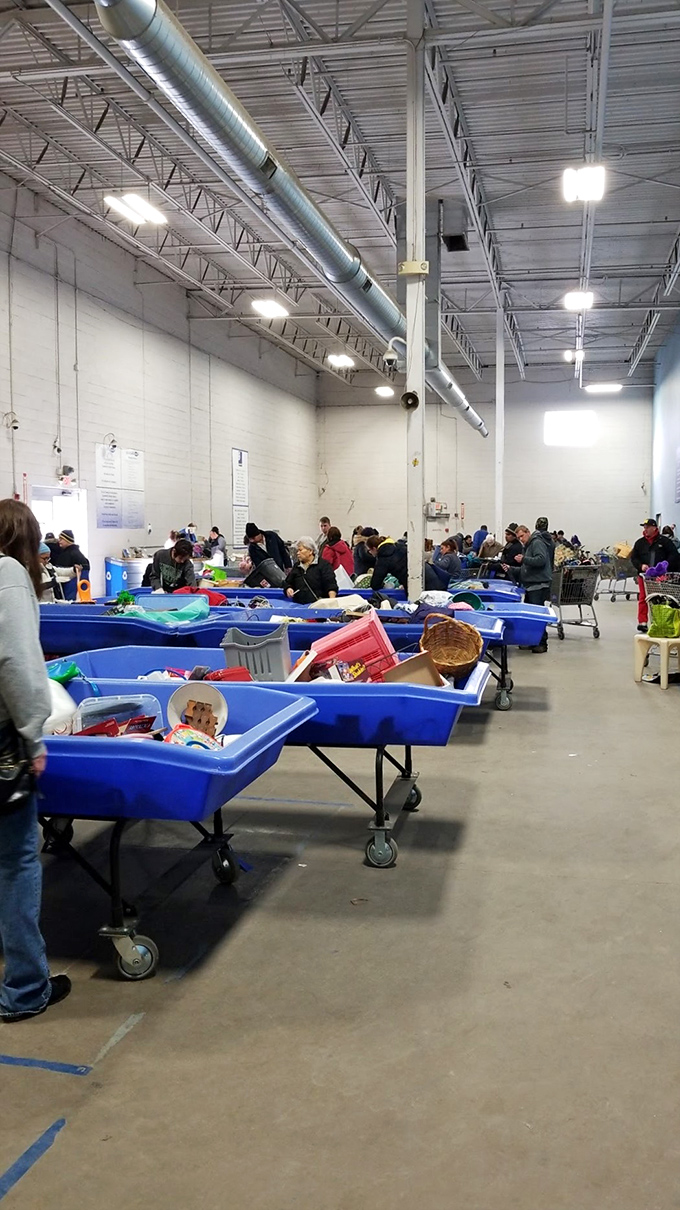 Welcome to the thunderdome of thrift! Shoppers strategically position themselves around blue bins, ready to pounce on the next great find.