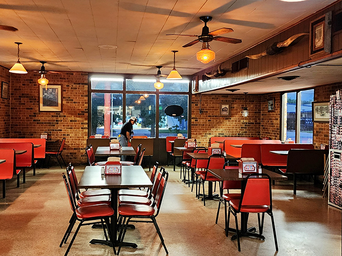 Red booths, exposed brick, and pendant lights create the kind of timeless diner atmosphere that Instagram wishes it invented.