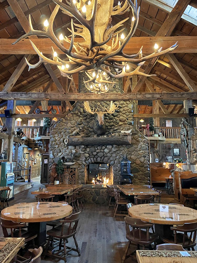Step inside to discover a cathedral-like interior where massive antler chandeliers hang from timber beams above a stone fireplace that could roast an entire moose.