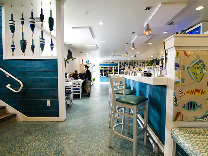 Fishing floats dangle from the ceiling while turquoise accents create the perfect nautical backdrop. You're not just in a restaurant&mdash;you're in a coastal escape.