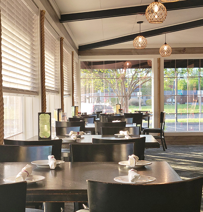 Nautical elegance meets cozy comfort in this sunlit dining area, where rope-wrapped columns and fisherman's pendant lights create the perfect backdrop for seafood indulgence.