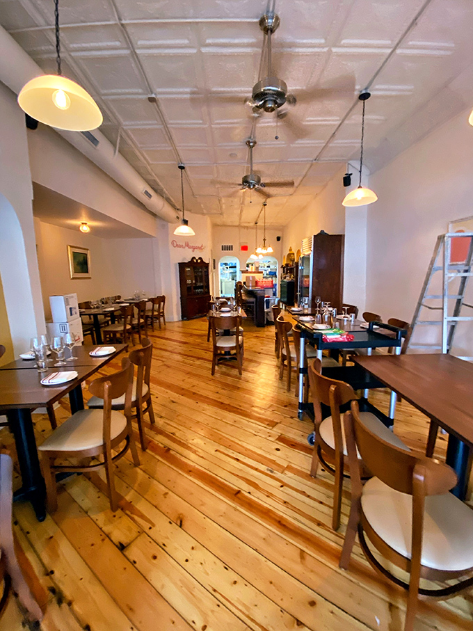 Natural light floods the dining room where wooden floors and tin ceilings create an atmosphere that's equal parts cozy and European.