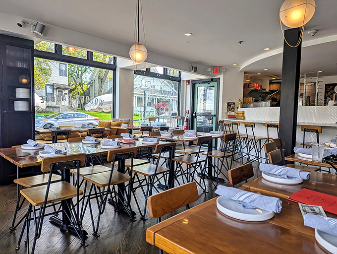 Bright, airy, and modern—the dining room balances industrial chic with warm wooden tables where pizza dreams come true.